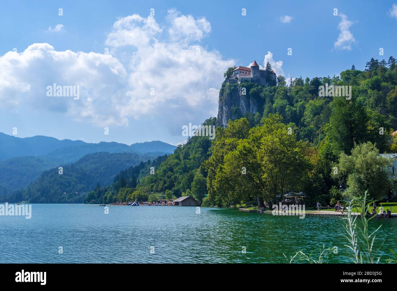 Medieval castle on the rock above the Lake Bled, Alpine mountains at ...