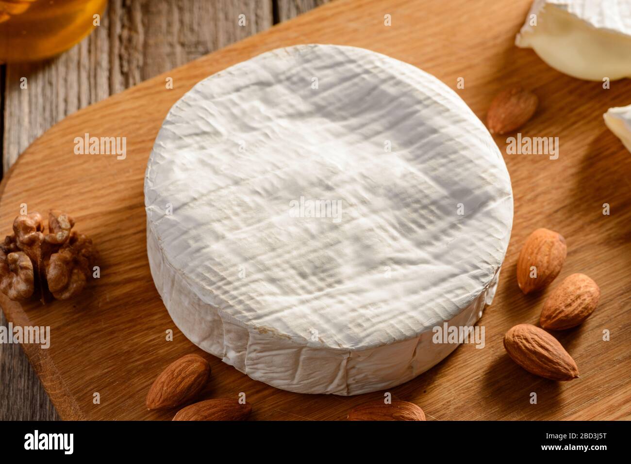 Whole Brie cheese with white rind. Served with almonds and walnuts ...