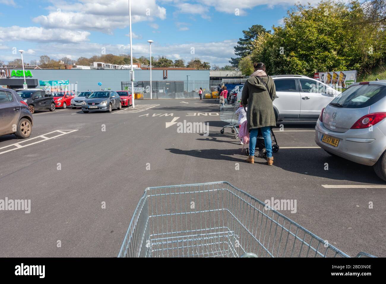 People queue in line observing social distancing waiting to enter a ...