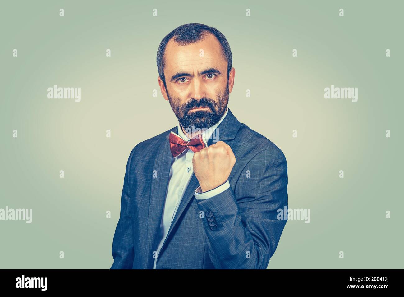 portrait of young angry man showing fist in anger isolated on light ...
