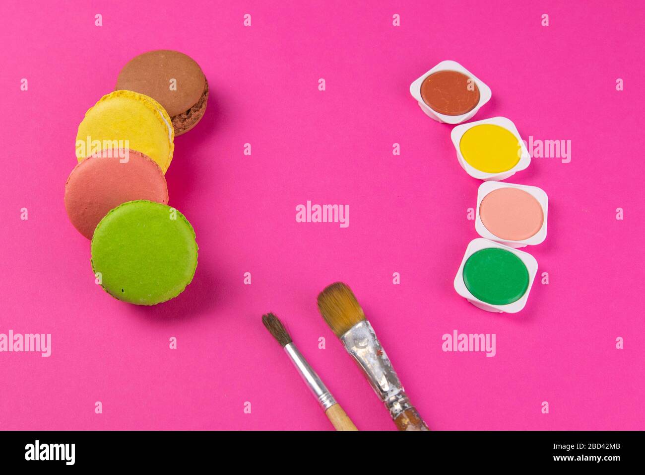 Makarons on a pink background are next to the colors of macaroons and ...