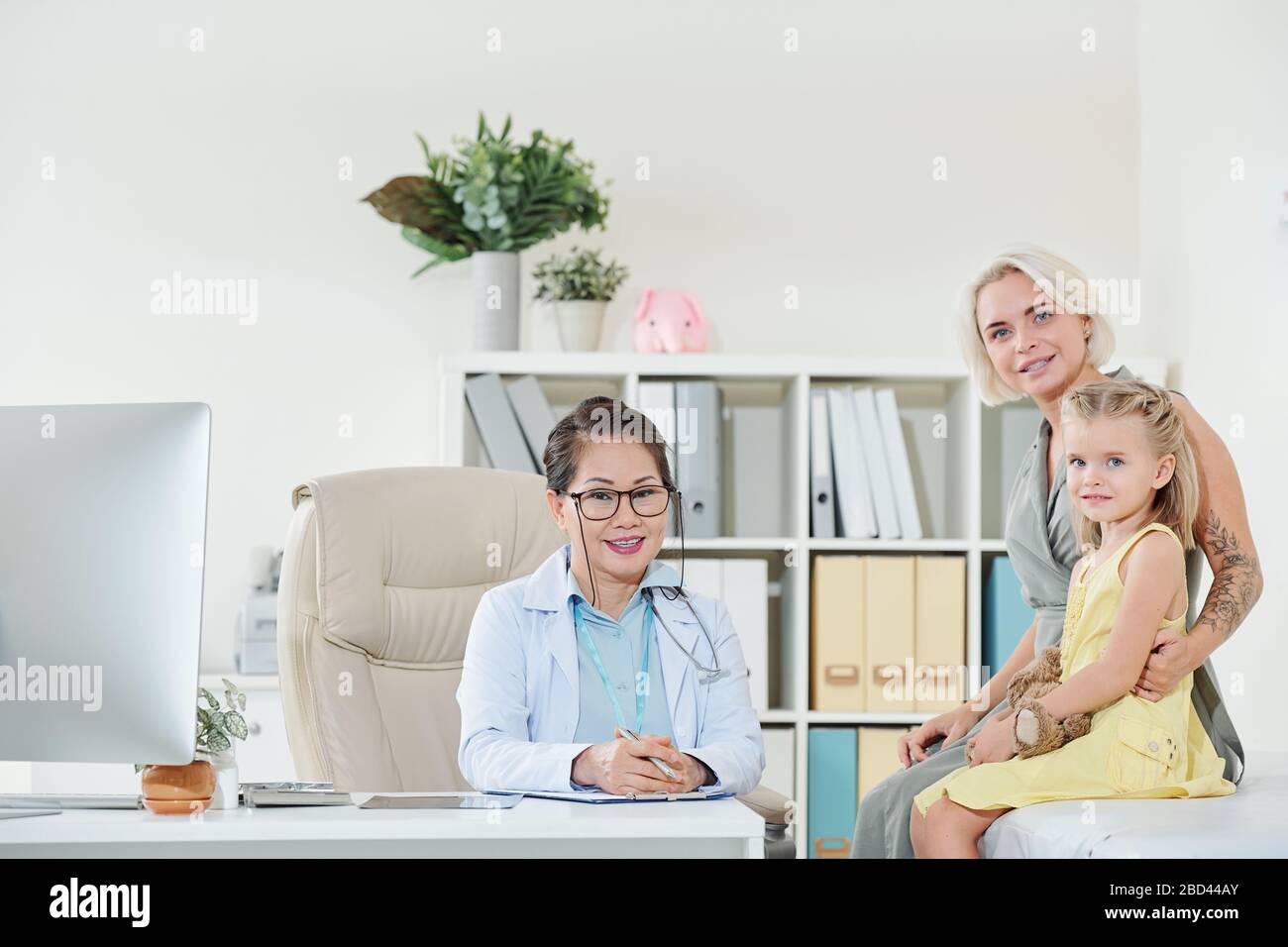 Smiling mother and little daughter visiting pediatrician for annual ...