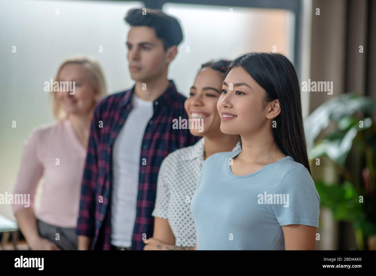 Multi-ethnical group of people standing close to each other and looking ...