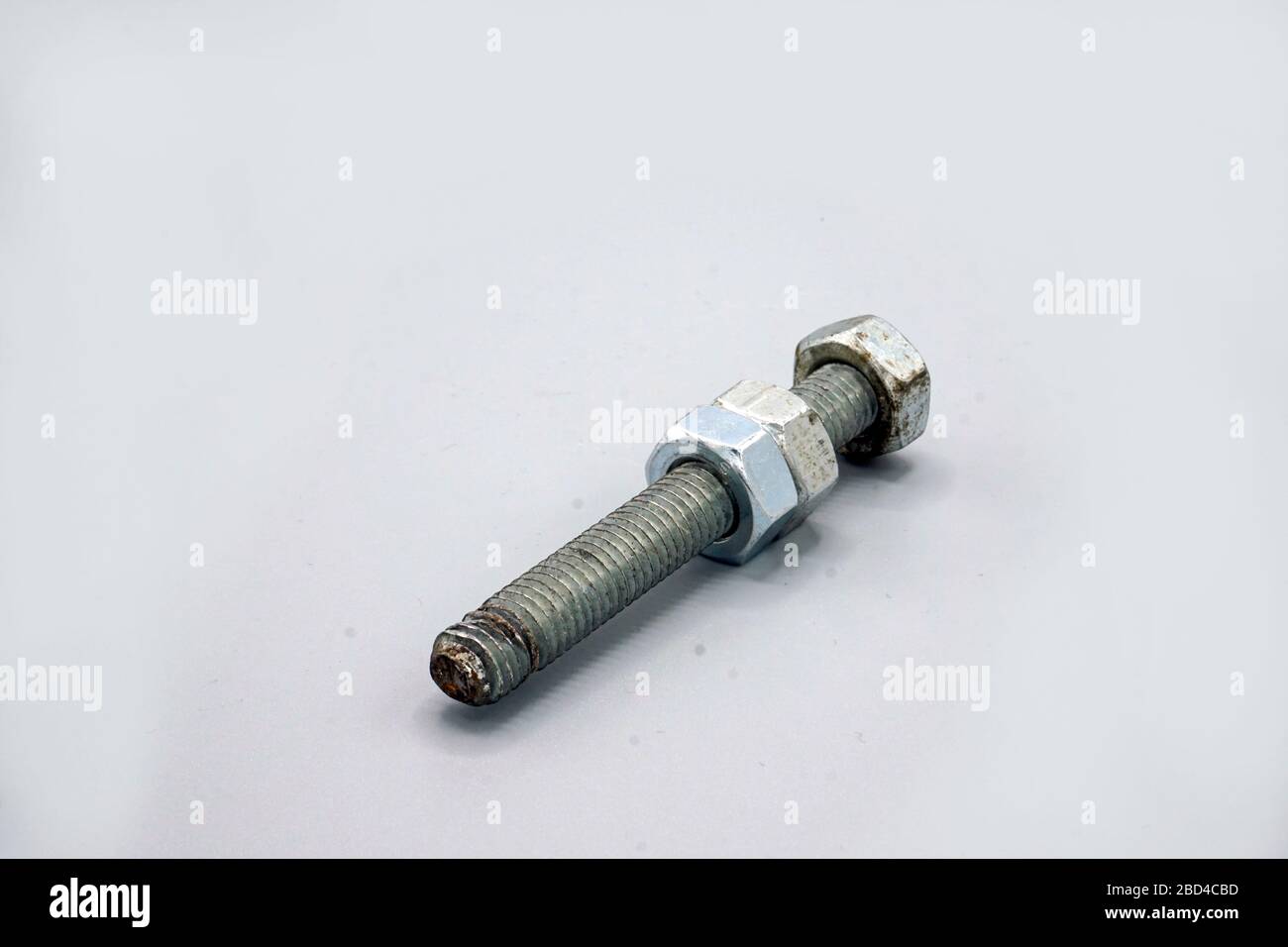 Stainless steel screws and nuts isolated on gray background. New and ...