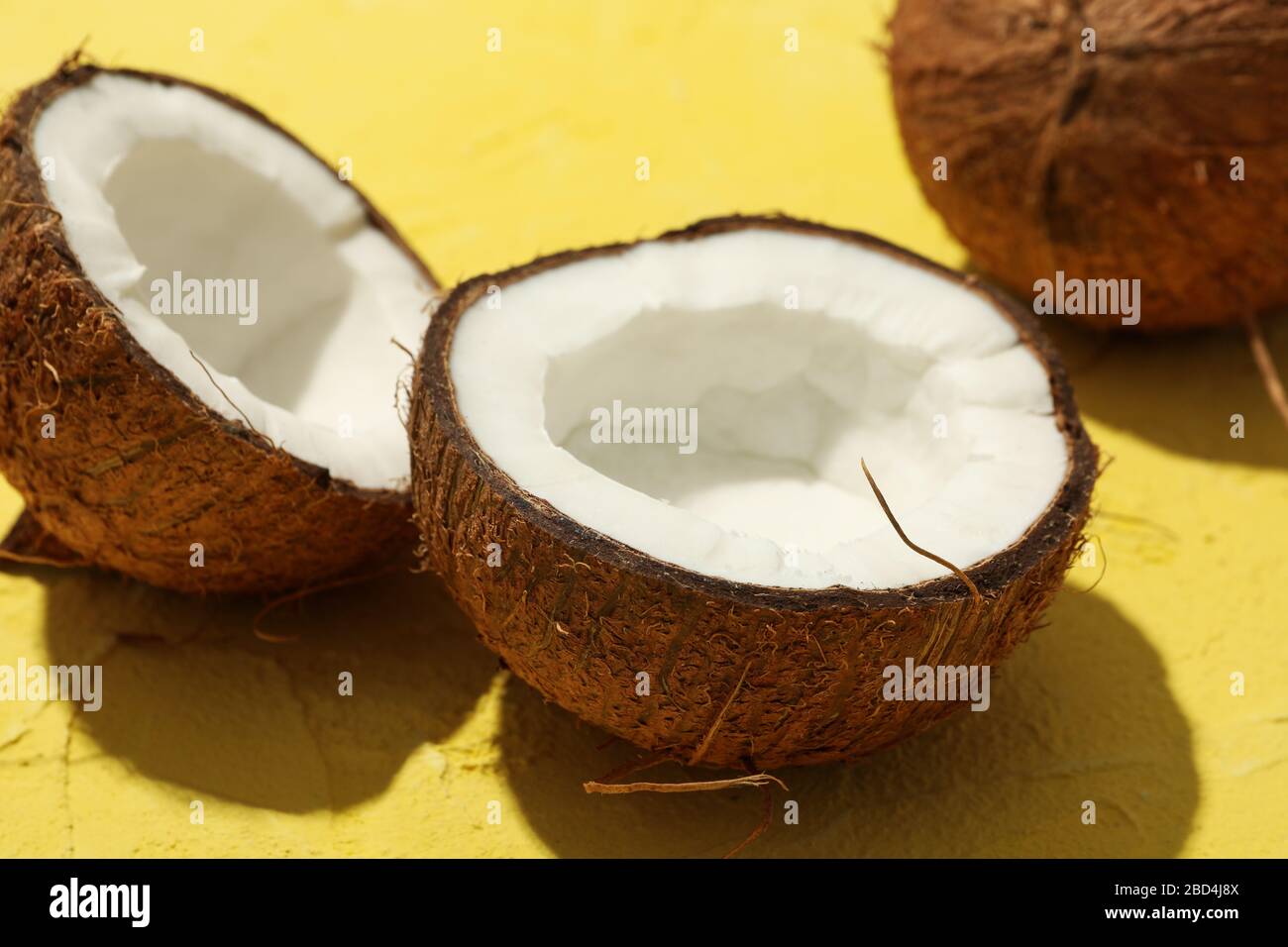 Coconut on yellow background, close up. Tropical fruit Stock Photo - Alamy
