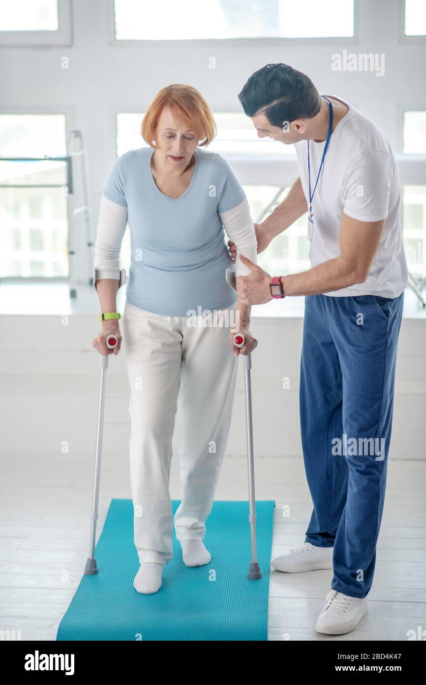 Nice helpful young man assisting his patient Stock Photo - Alamy