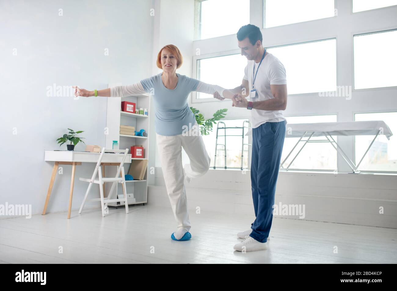 Positive active woman standing on one leg Stock Photo - Alamy