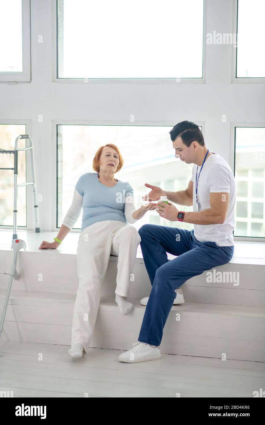 Smart skilled doctor giving his patient her daily dose of medicine ...