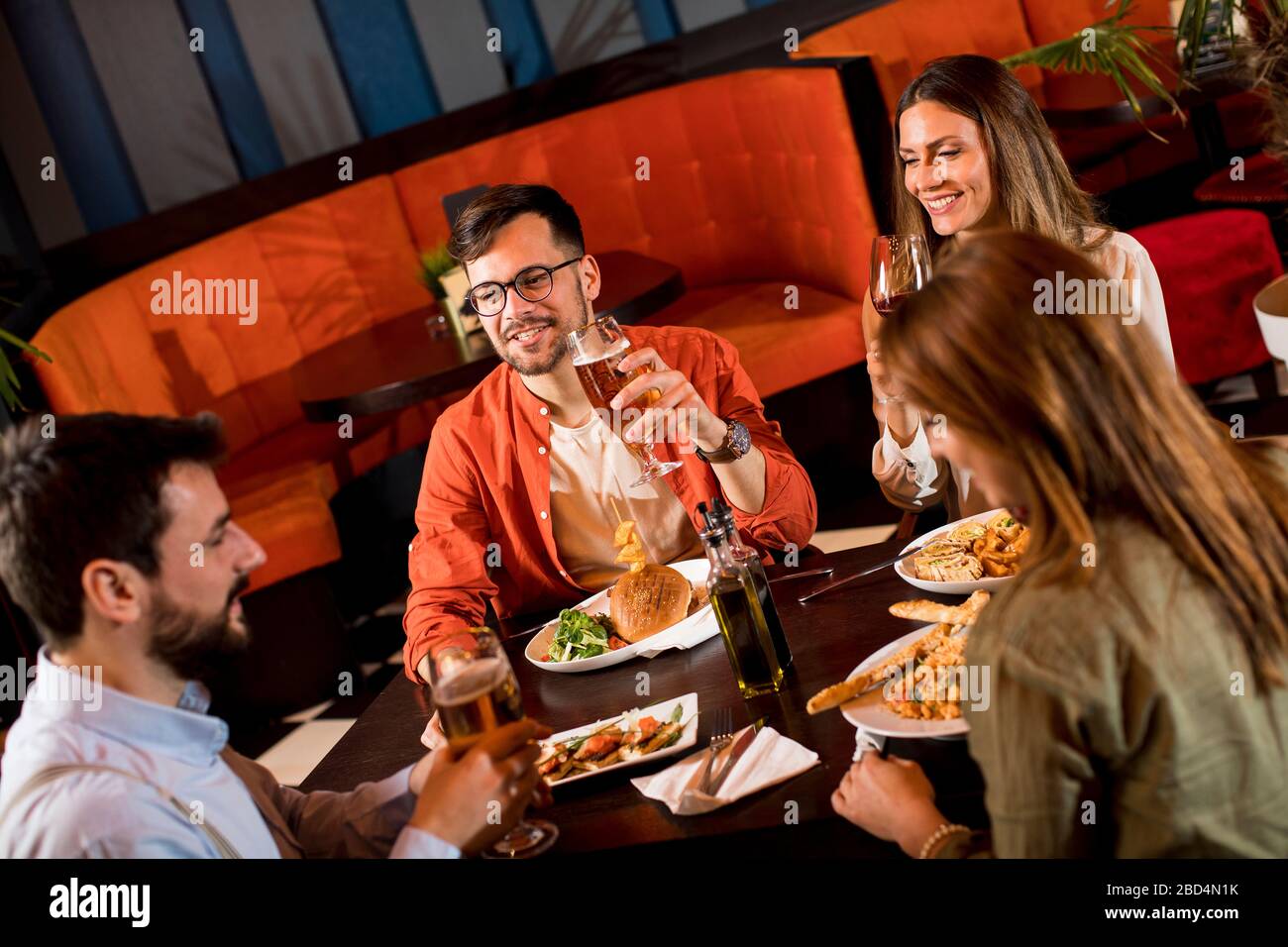 Group of young people having dinner in the restaurant Stock Photo - Alamy
