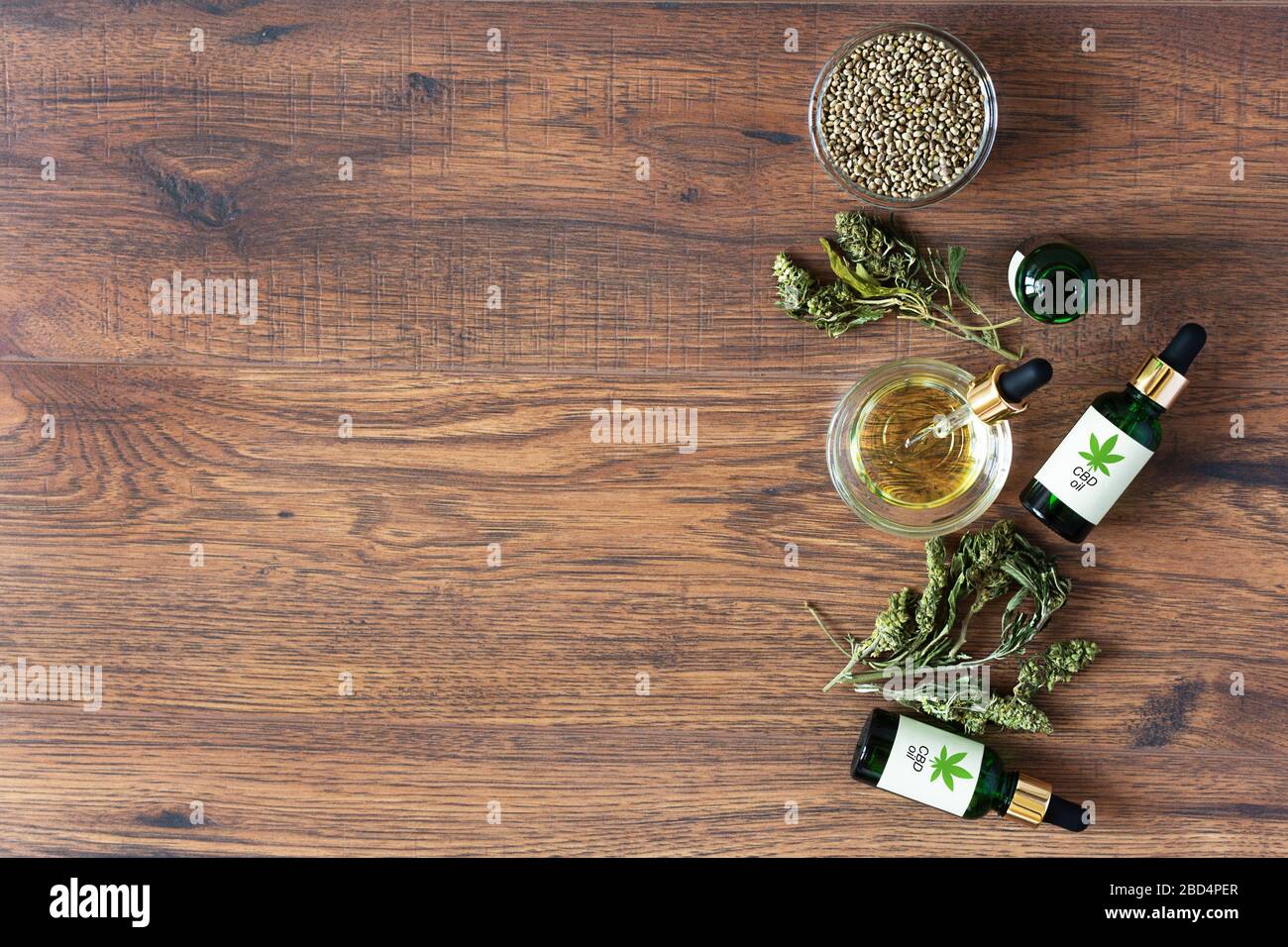 Green bottles of medical CBD oil with cannabis seeds and dried leaves ...