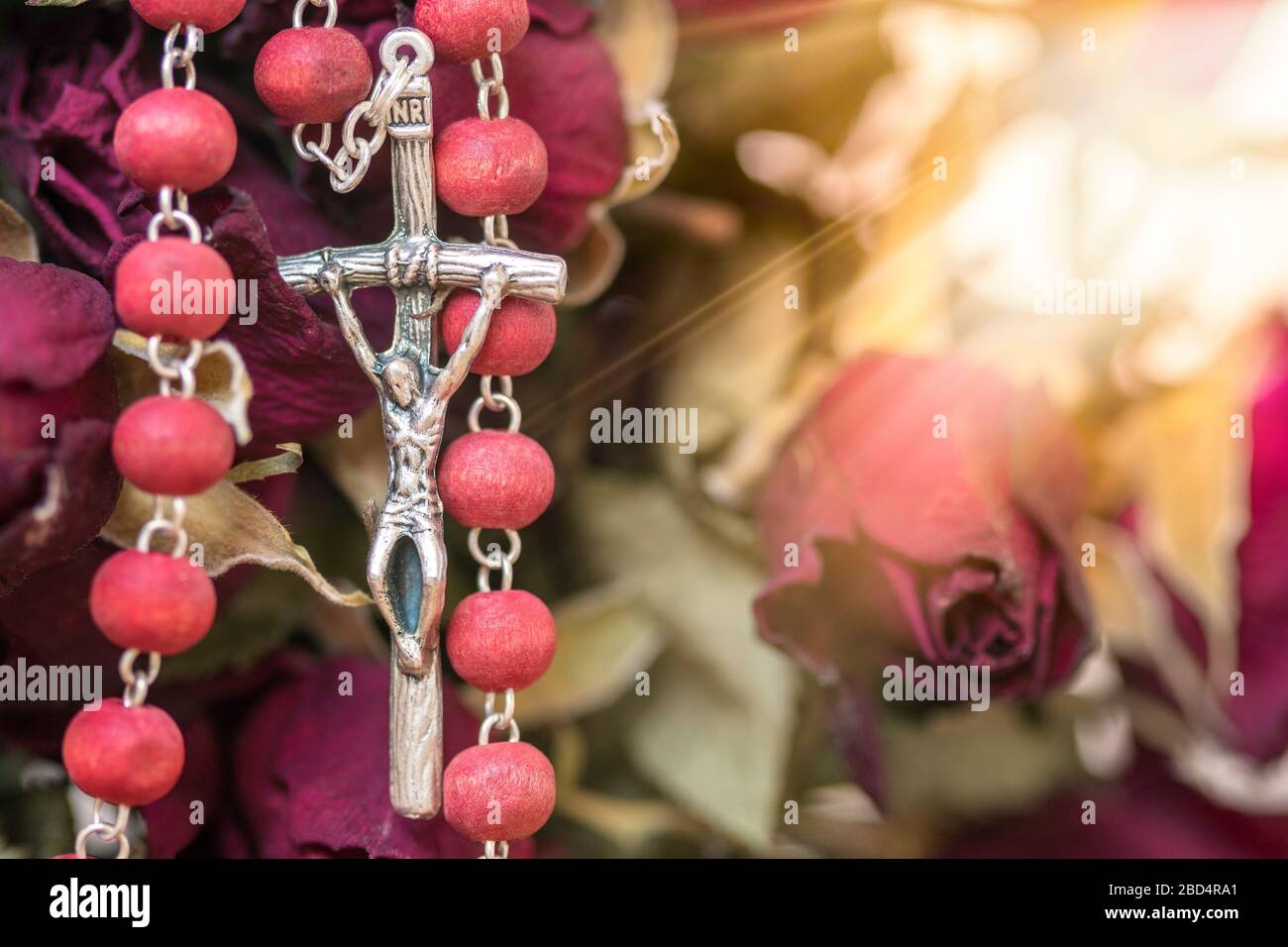 Catholic rosary and dry roses, close-up view. Faith and hope concept ...