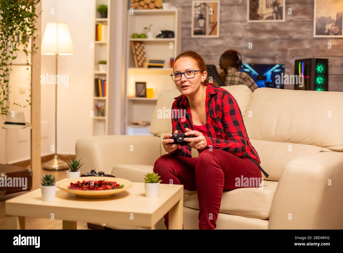 Woman gamer playing video games on the console in the living room late ...