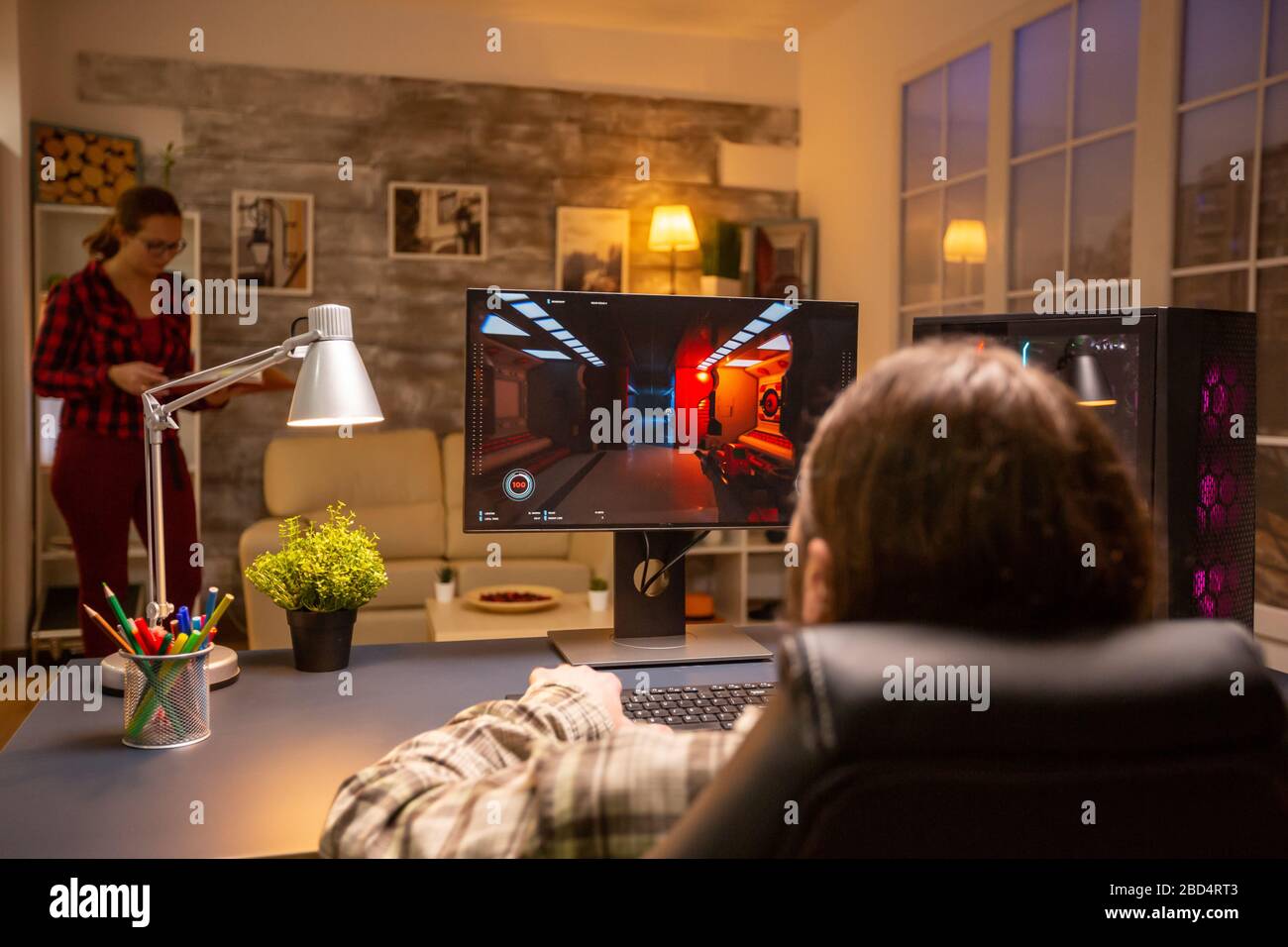 Back view of professional video gamer playing on powerful PC late at ...