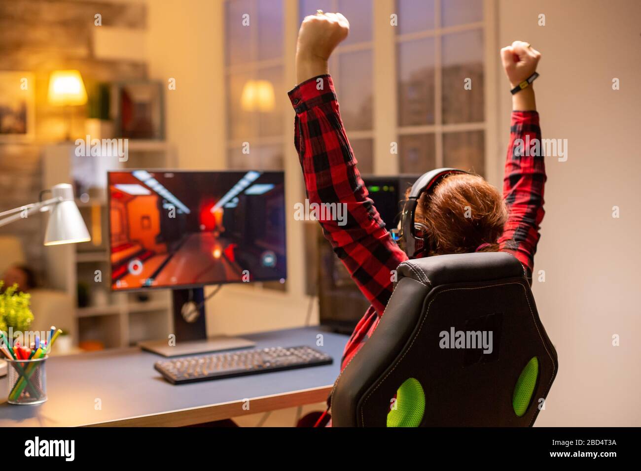 Happy excited gamer winning a online video game late night in the ...