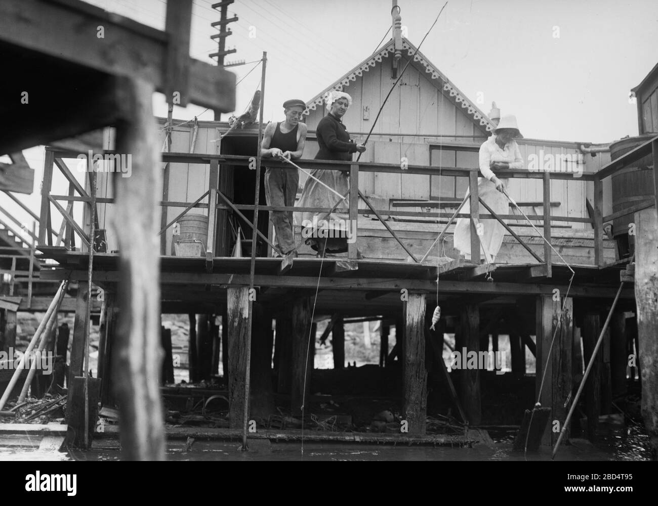 Men fishing off the front porch of a house in Broad Channel, Queens ca ...
