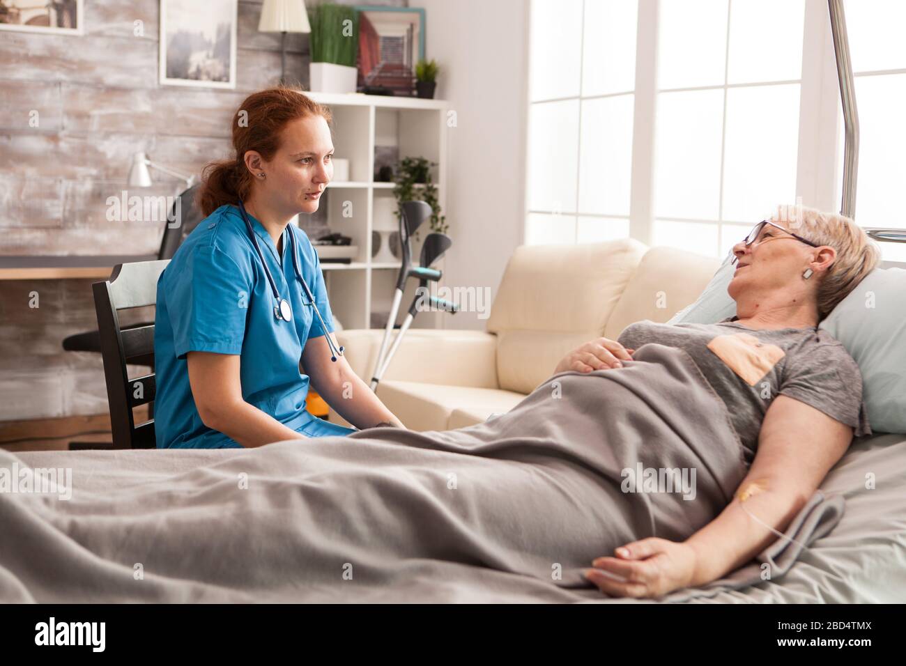 Friendly nurse visiting recovery senior patient in nursing home Stock ...