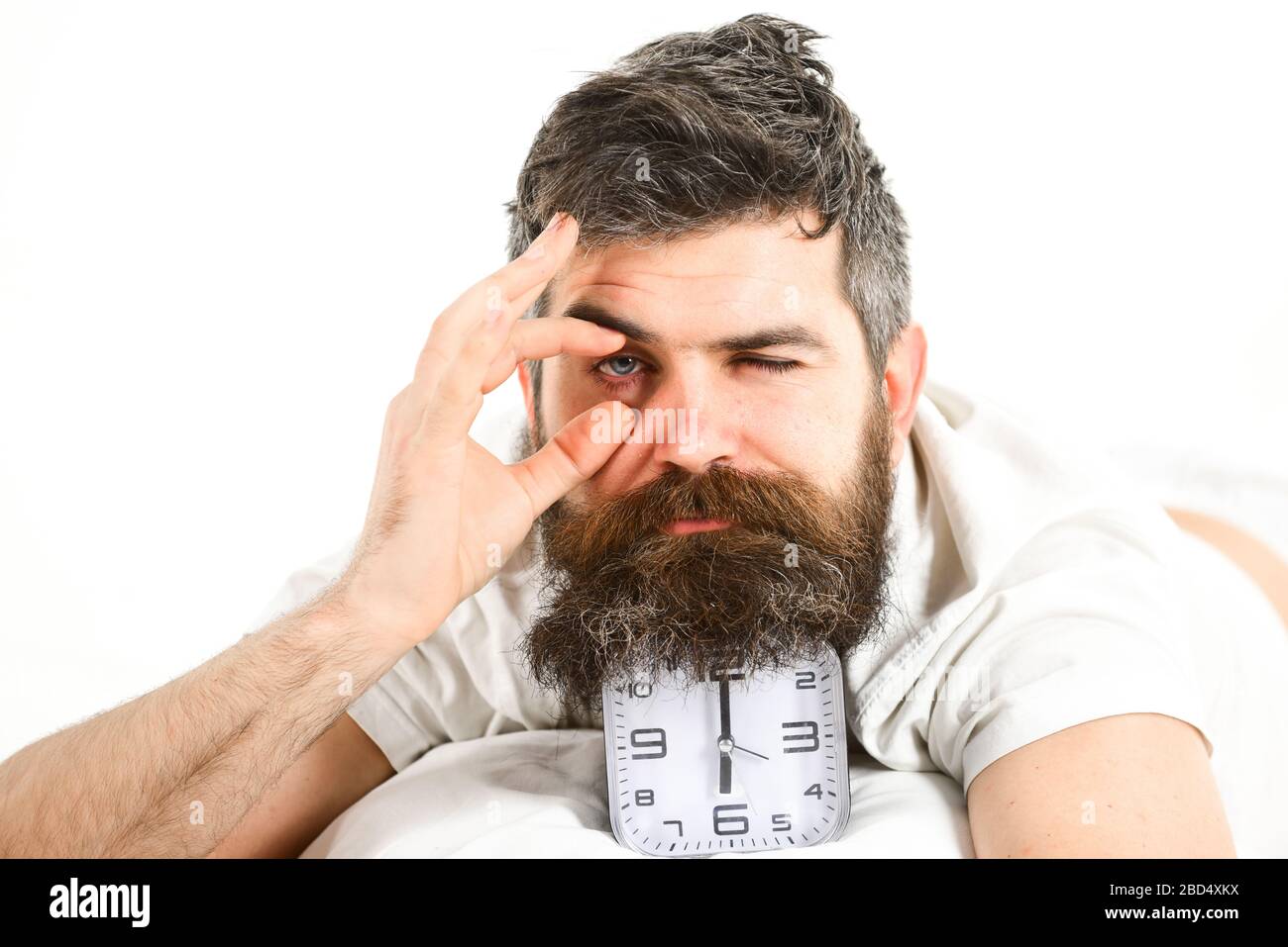 Tired man trying to open his eyes in morning. Hipster with beard and ...