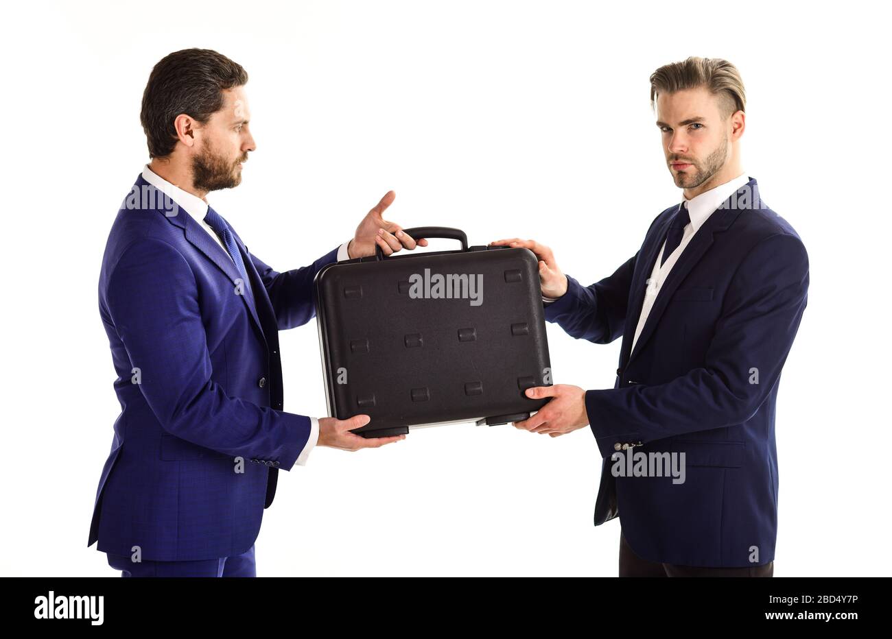 Businessmen with serious faces hold black briefcase. Handover of ...