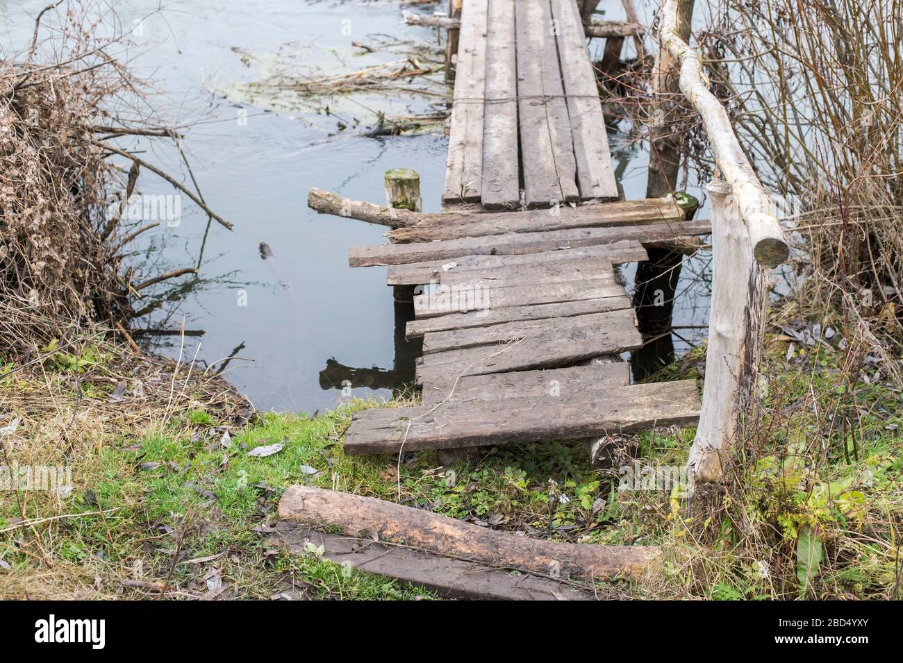 Wooden bridge over a small river in the village in autumn. Background ...