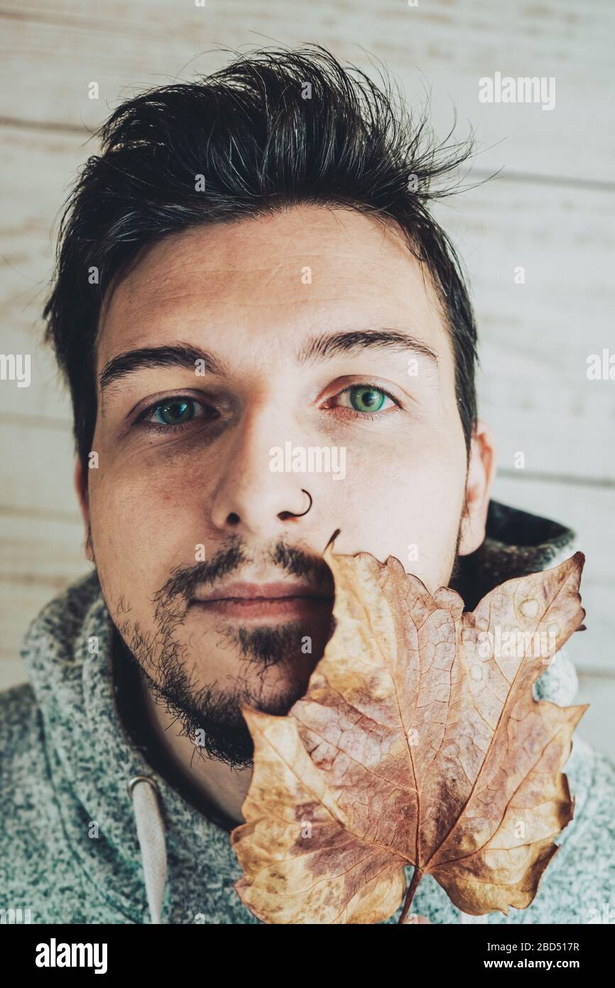 Young man covering his face with a dry leaf Stock Photo - Alamy