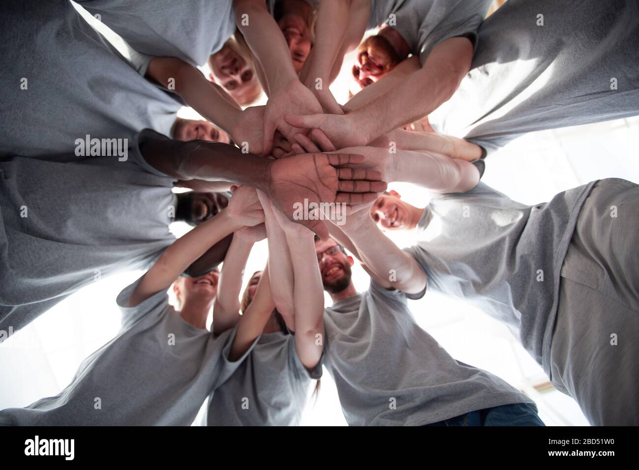 smiling young people making a tall tower out of their hands Stock Photo ...