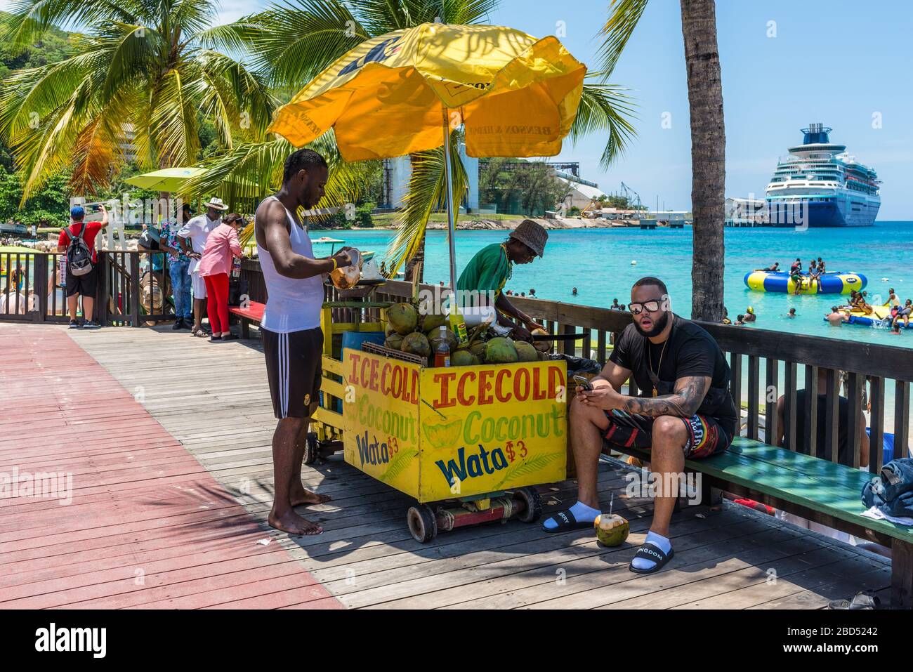 Ocho Rios, Jamaica - April 22, 2019: The seller of coconut is prepares ...