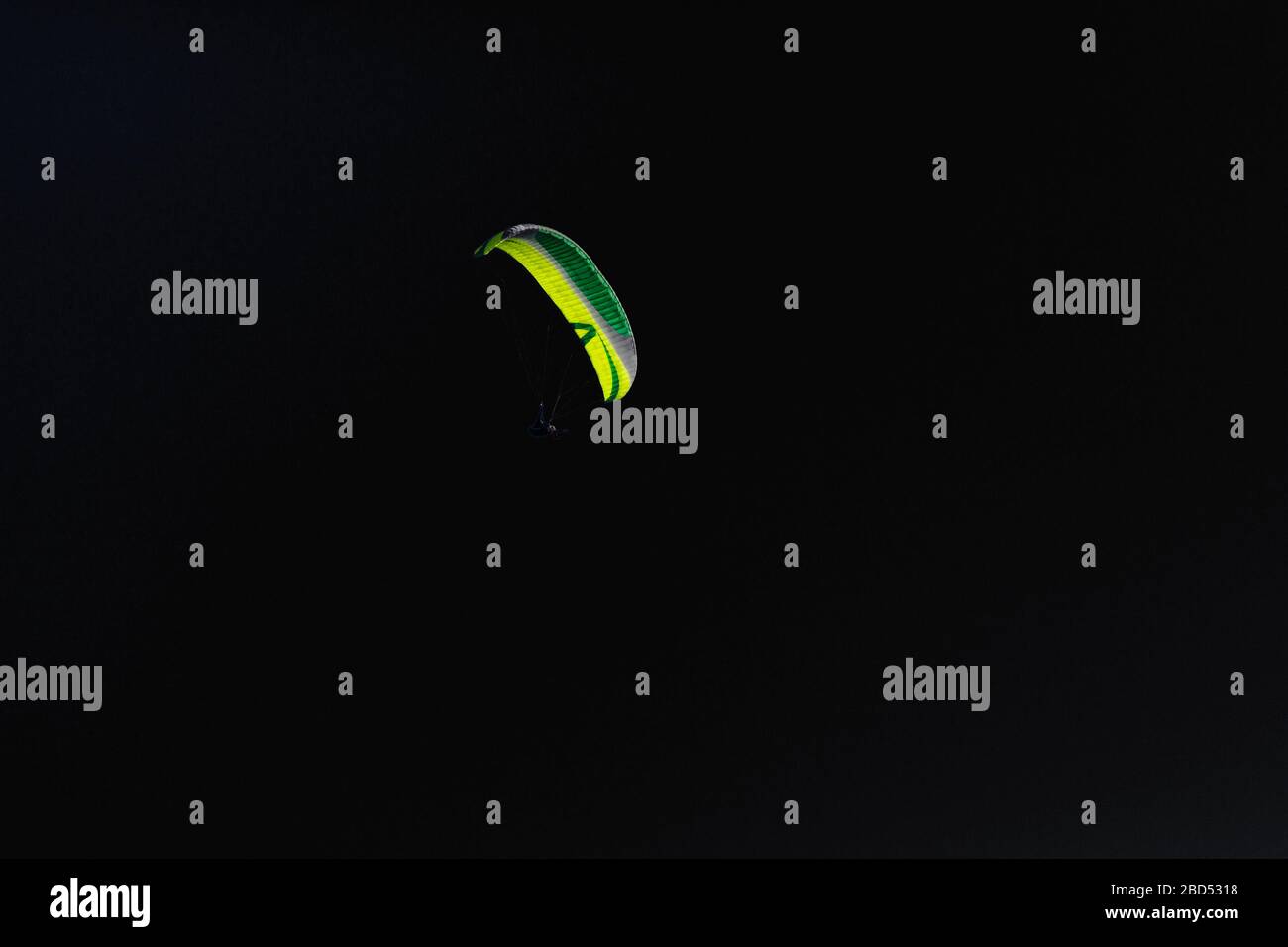 Green parachute on a black background Stock Photo - Alamy