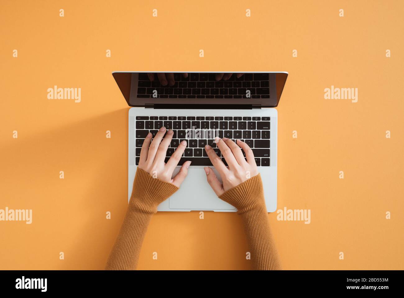 Human using laptop top view on minimal workspace. Color background and ...