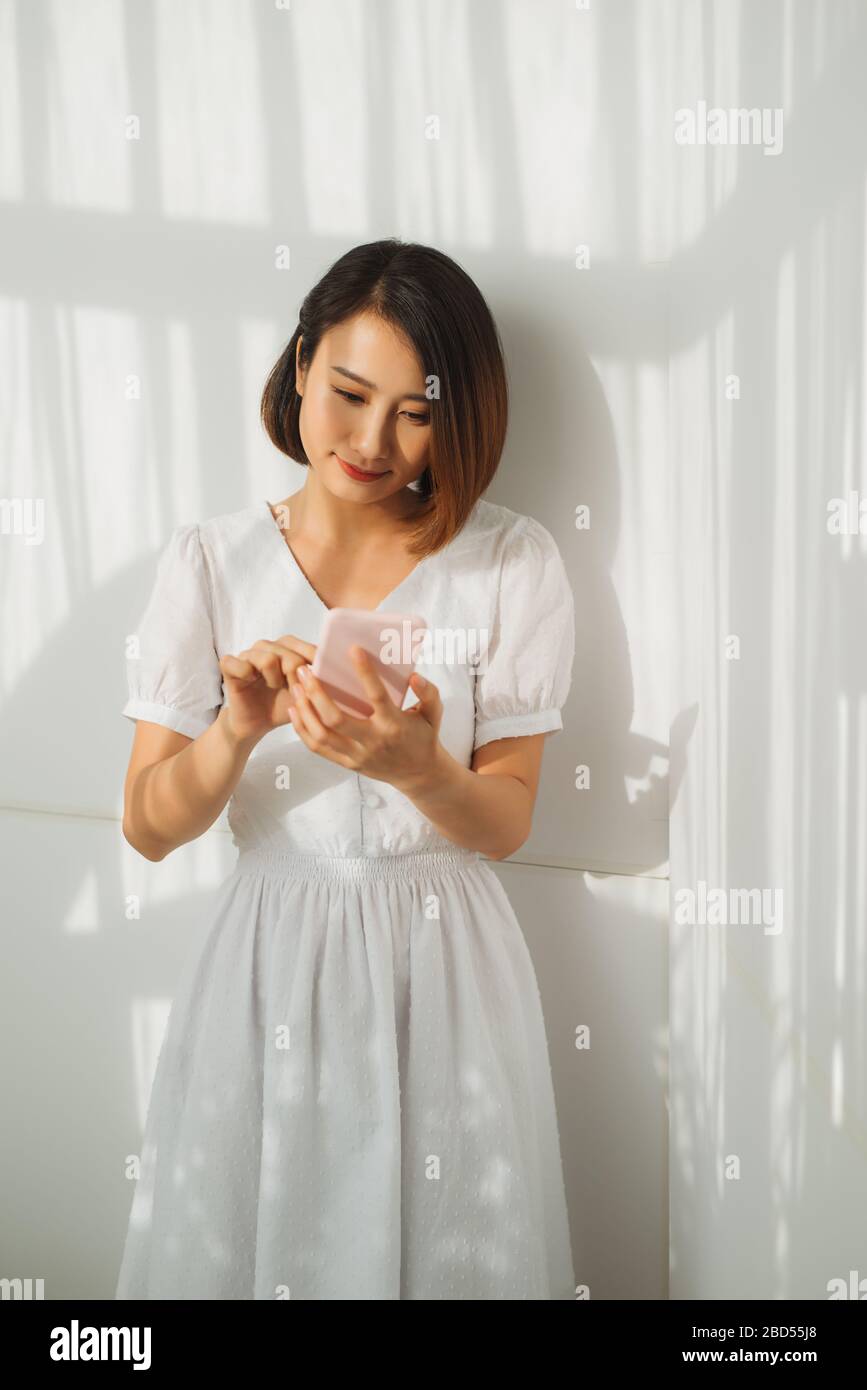 Young woman texting on her smartphone with a look of concentration as ...