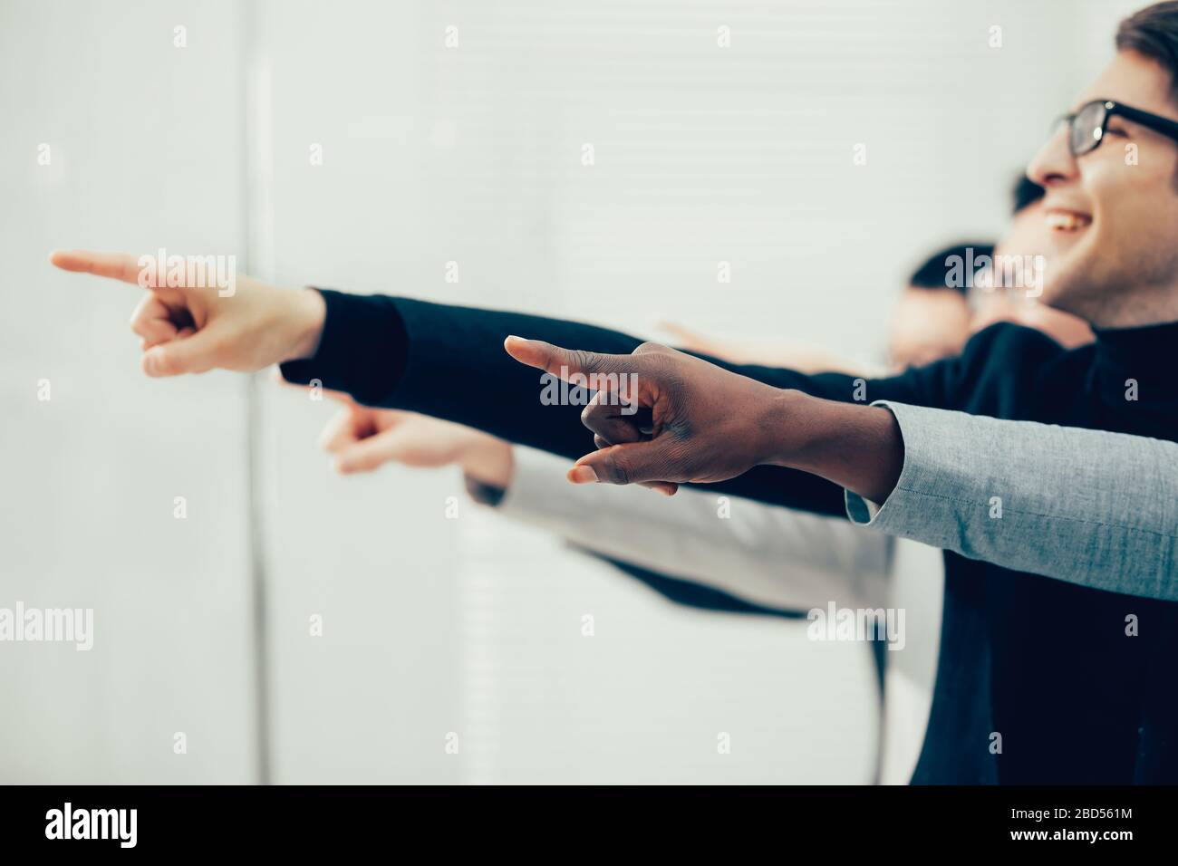 group of smiling business people pointing pointing forward Stock Photo ...