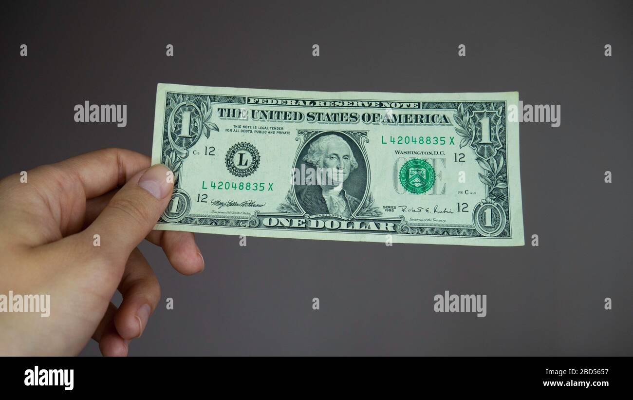 One US dollar in hand. One dollar bill. George Washington Stock Photo ...