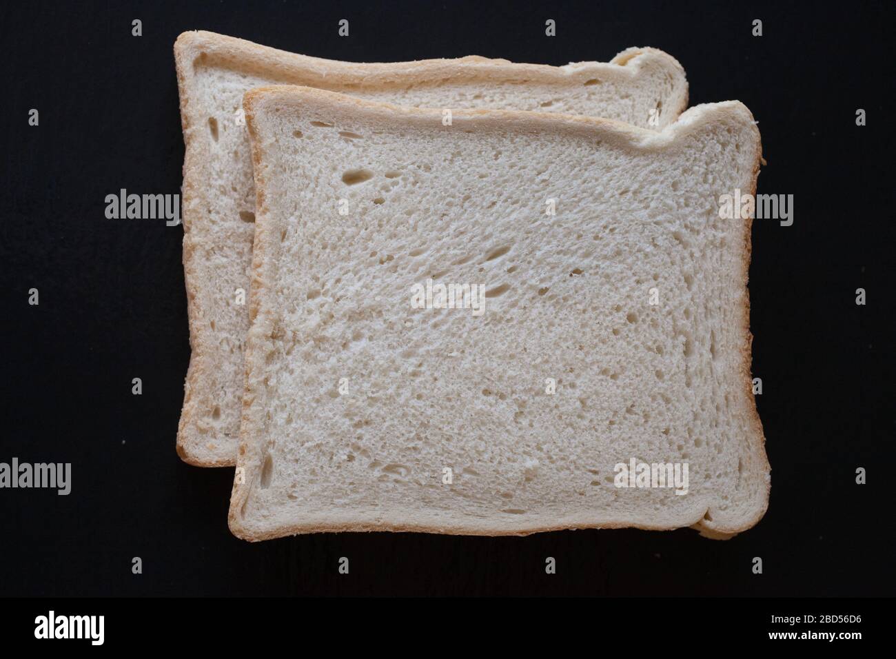 Two slices of white bread photographed in a black background Stock ...