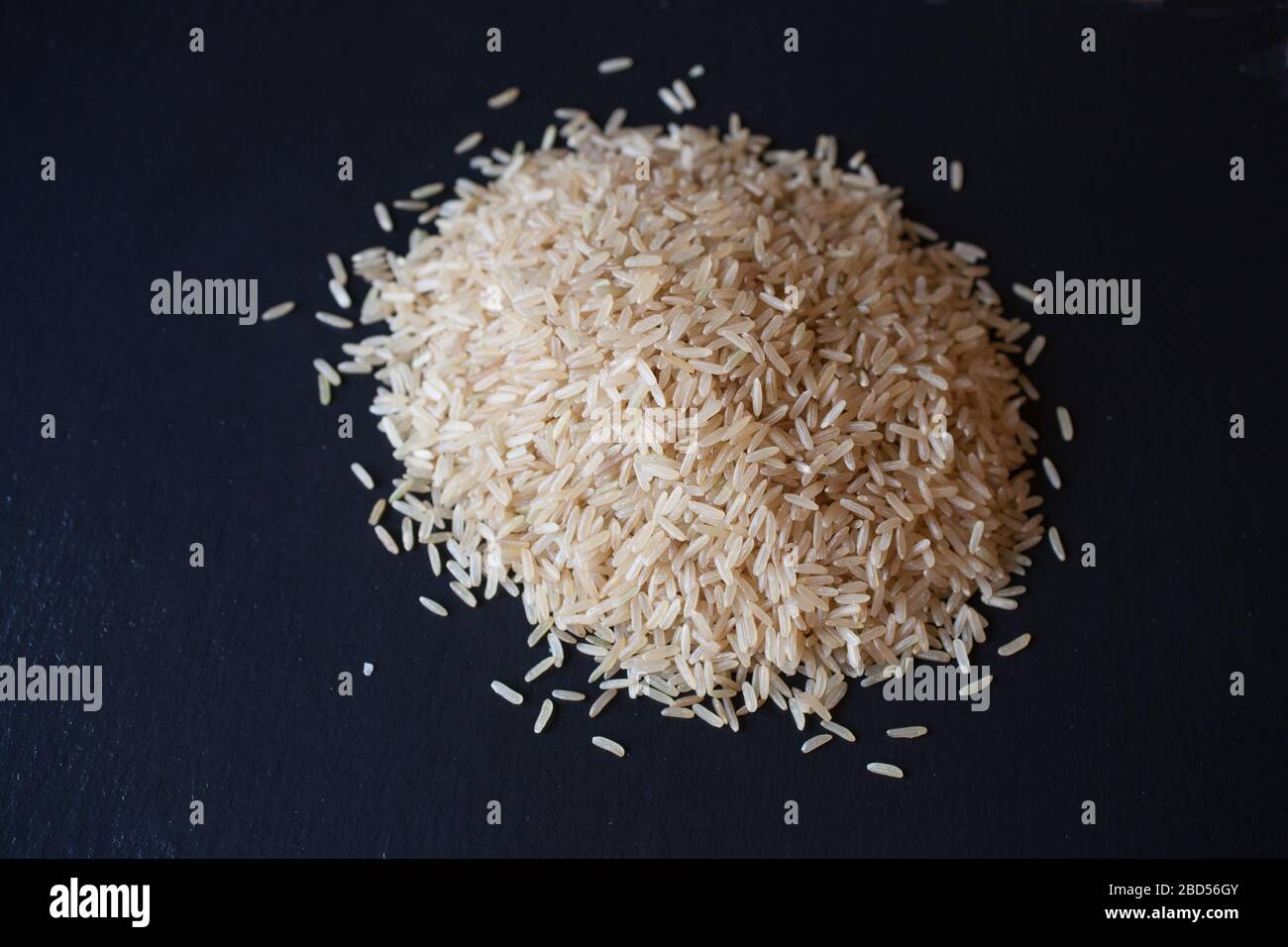 A heap of brown rice photographed from above on black slate Stock Photo ...