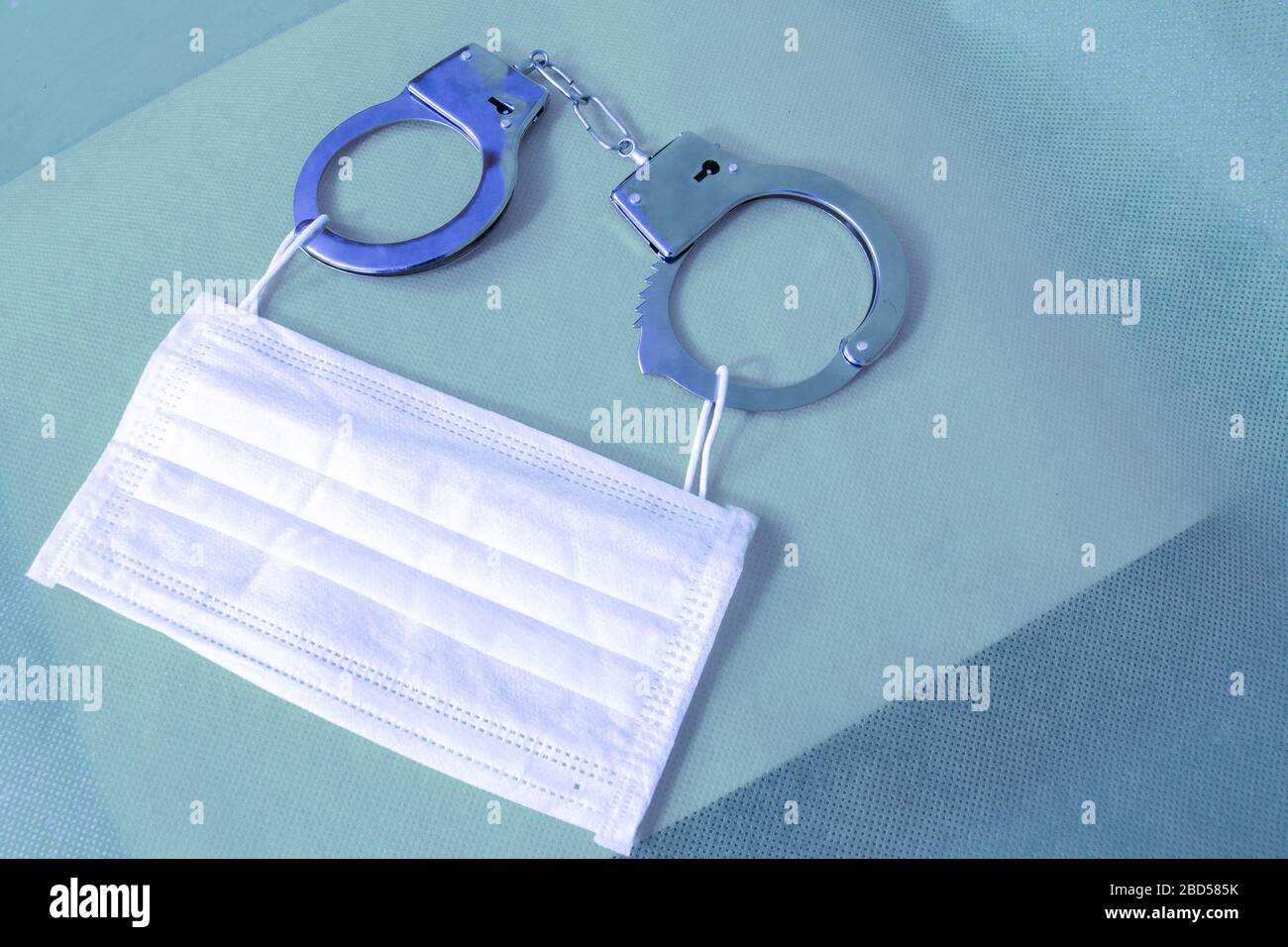 the concept of a medical mask and handcuffs. Surgical mask with rubber ...