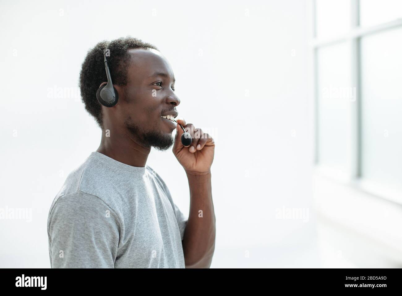 side view. young man with headset talking into microphone Stock Photo ...