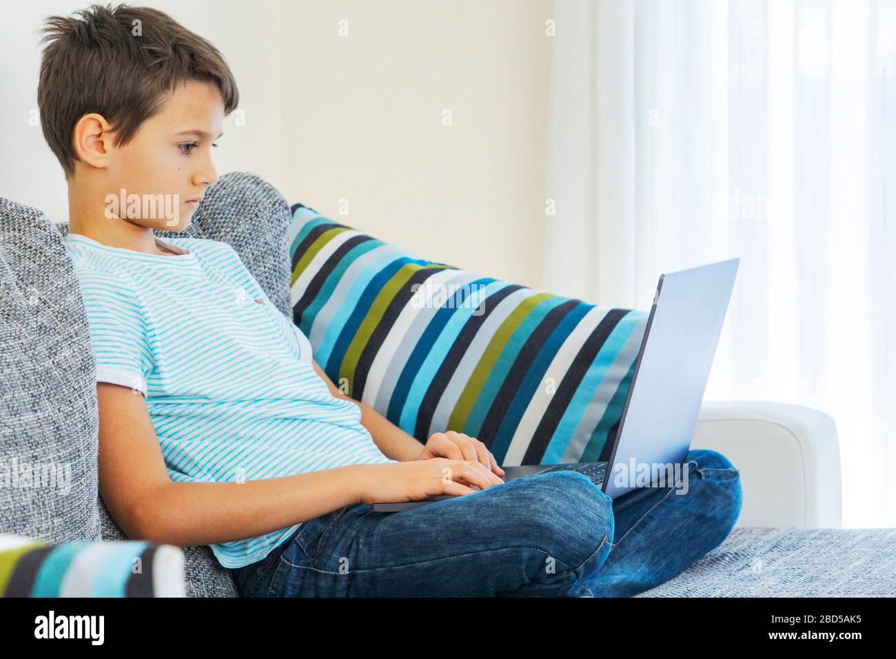 Preteen boy using laptop computer at home. Technology, online learning ...