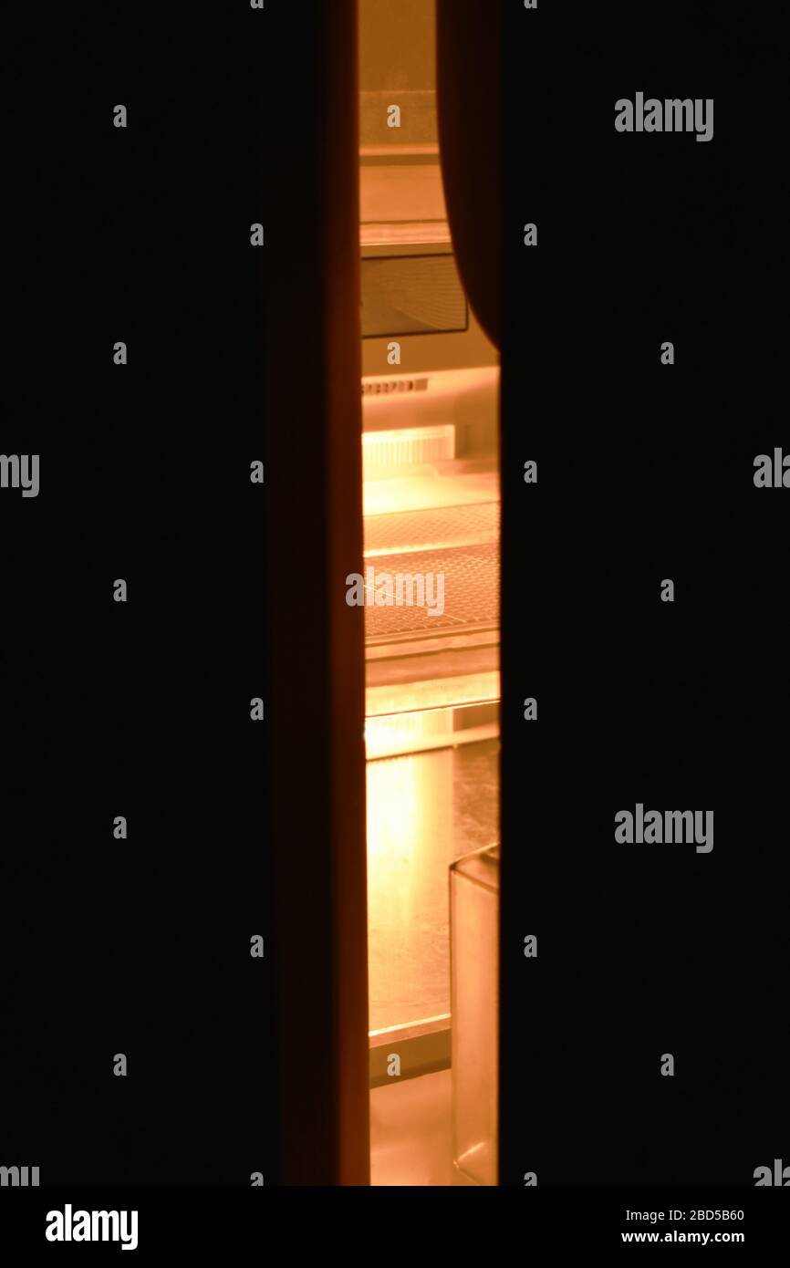 light sift out from refrigerator door ajar out in the dark Stock Photo ...