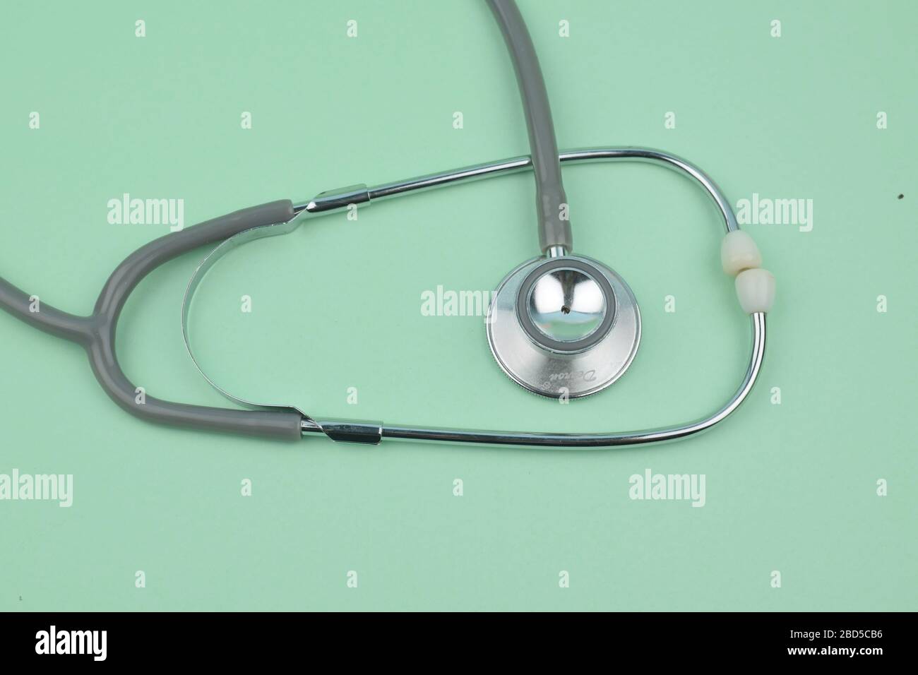 Single stethoscope isolated on a green color paper background with the ...