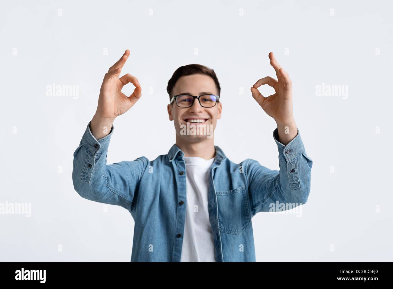 Focus on fingers showing ok. Guy in glasses on white background Stock ...