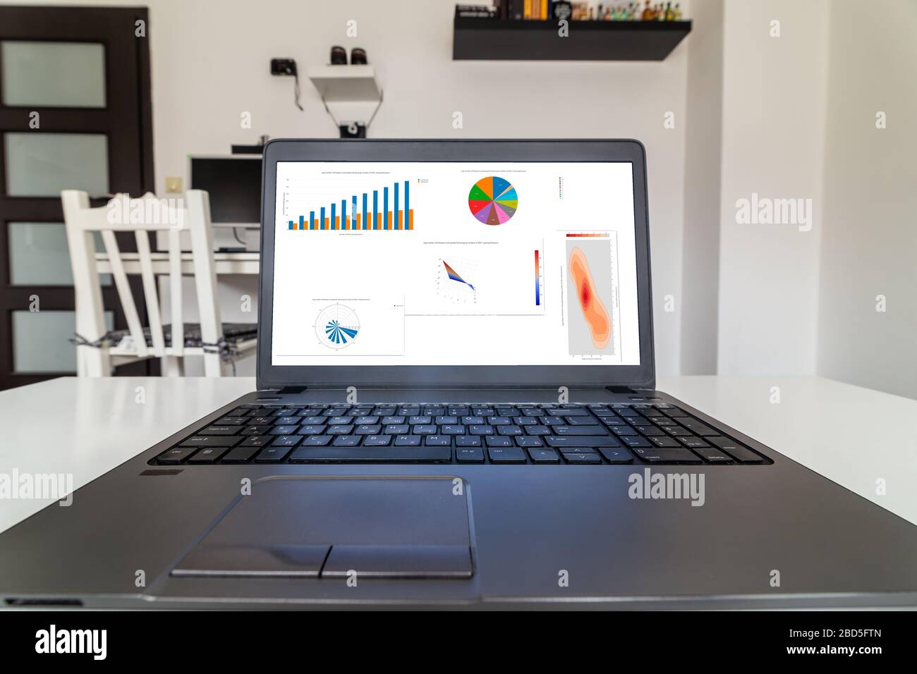 Working from home concept. Man looking at business intelligence charts ...