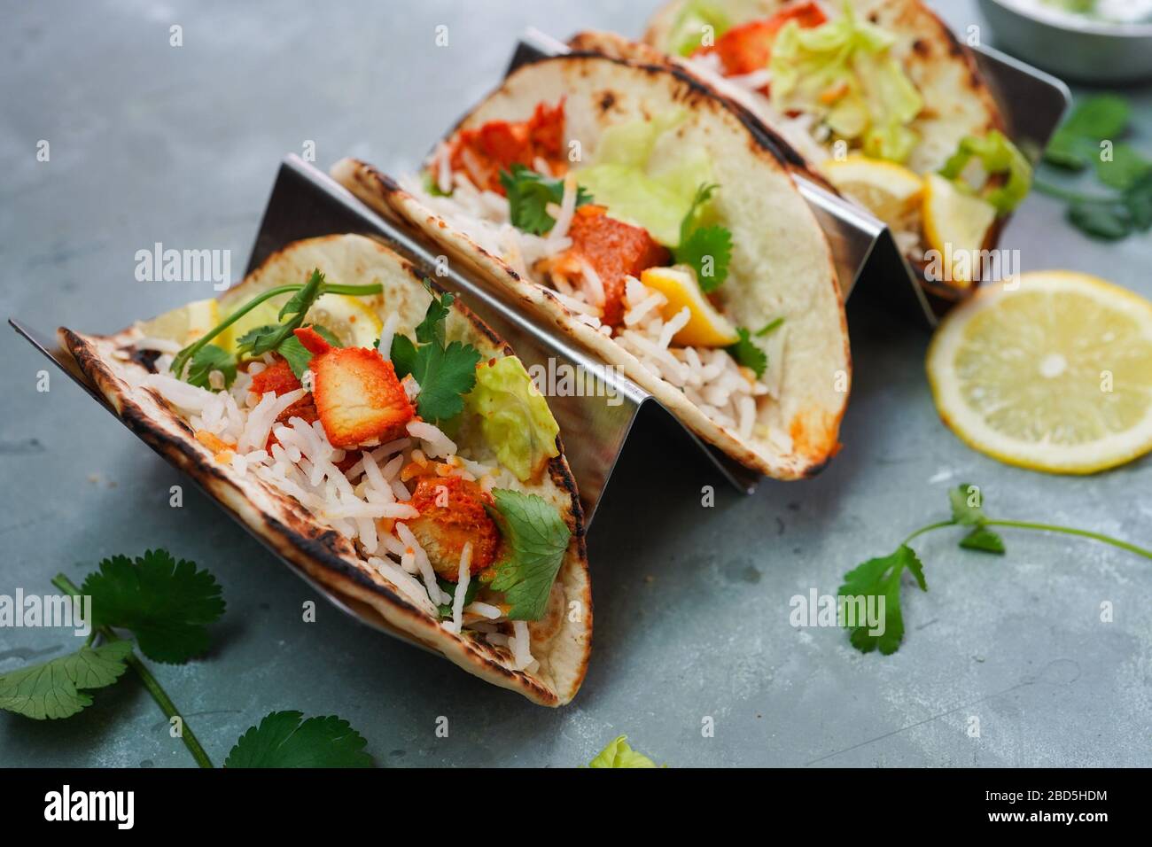 Homemade Chicken Tikka Tacos served in a metal Taco stand, selective ...