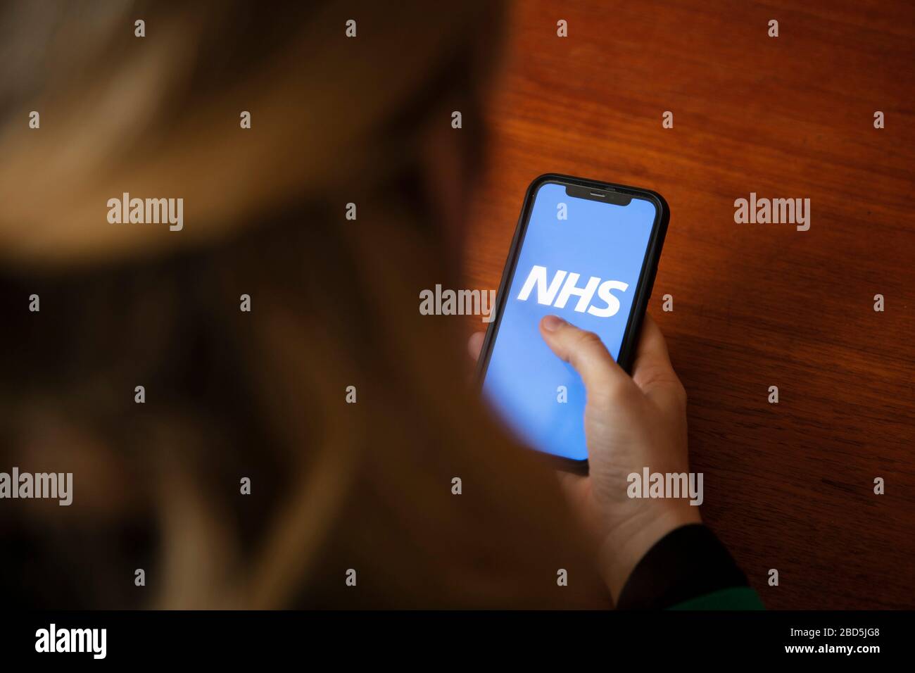 LONDON, UK - April 6th 2020: A person using the NHS healthcare ...