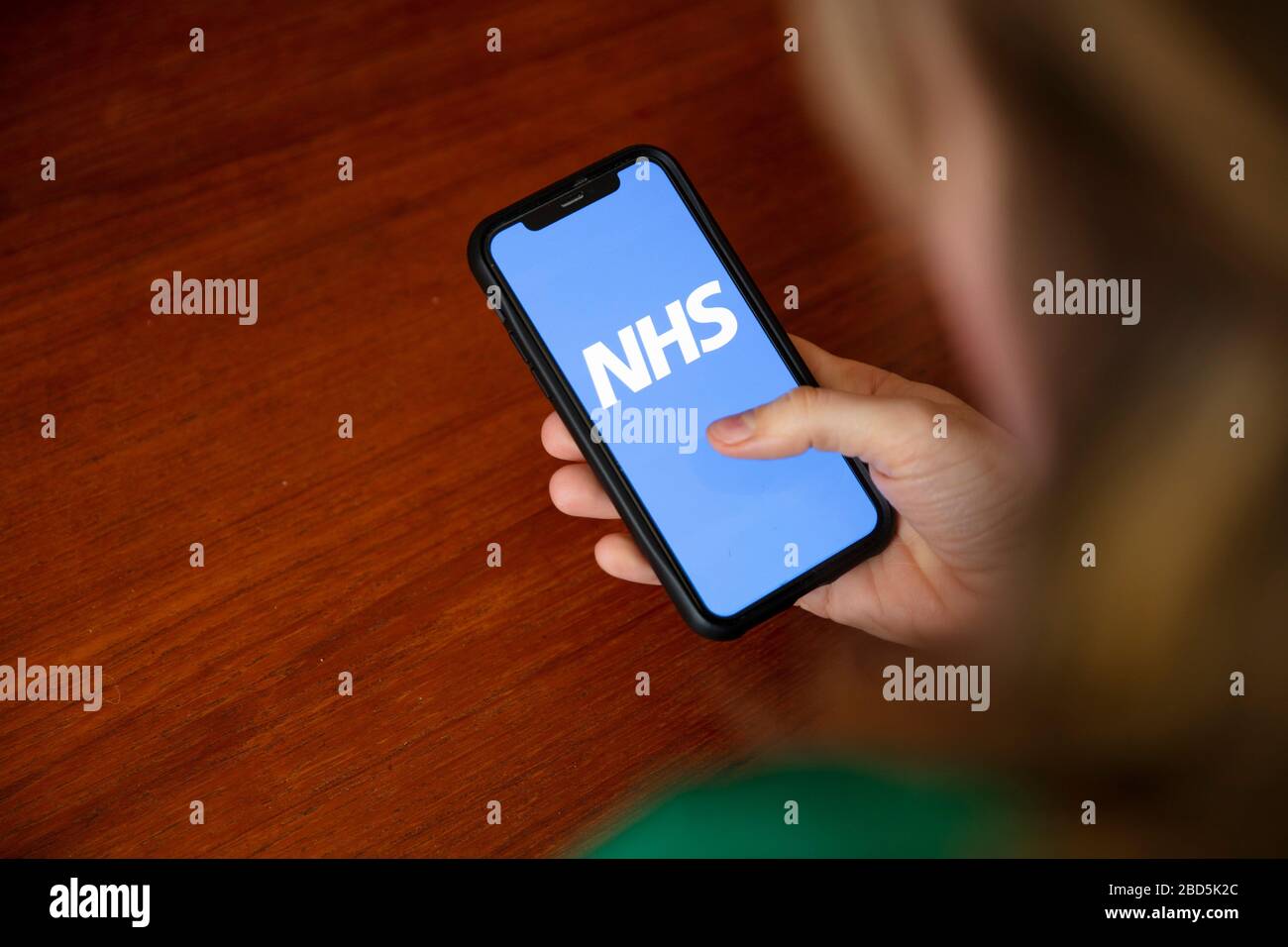 LONDON, UK - April 6th 2020: A person using the NHS healthcare ...