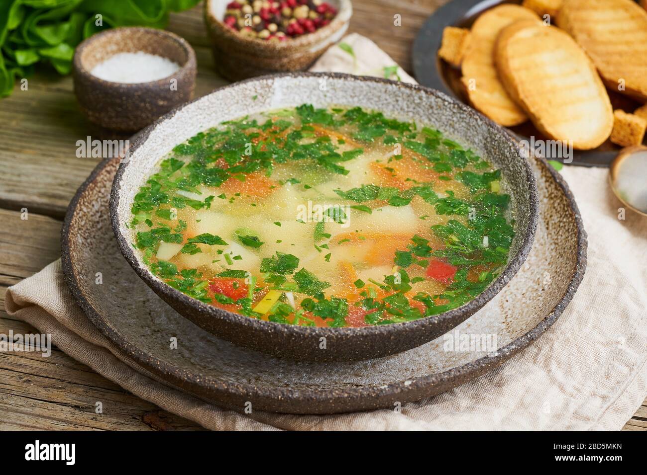 Rustic chicken soup with garnish, parsley, vegetables, homemade dish on ...