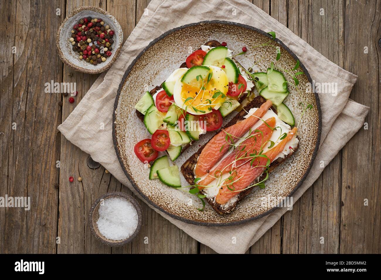 Smorrebrod - traditional Danish sandwiches. Black rye bread with salmon, cream cheese, cucumber ...