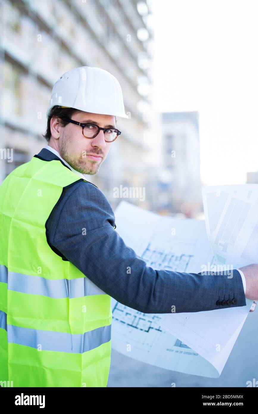 Young and attractive architect / civil engineer at work on a ...