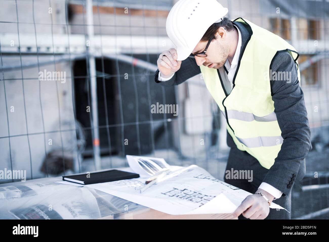 Young and attractive architect / civil engineer at work on a ...