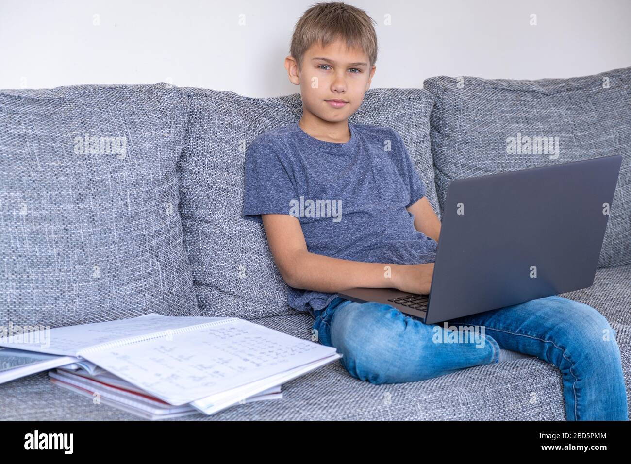 Preteen boy doing homework mathematics tasks with laptop computer at ...