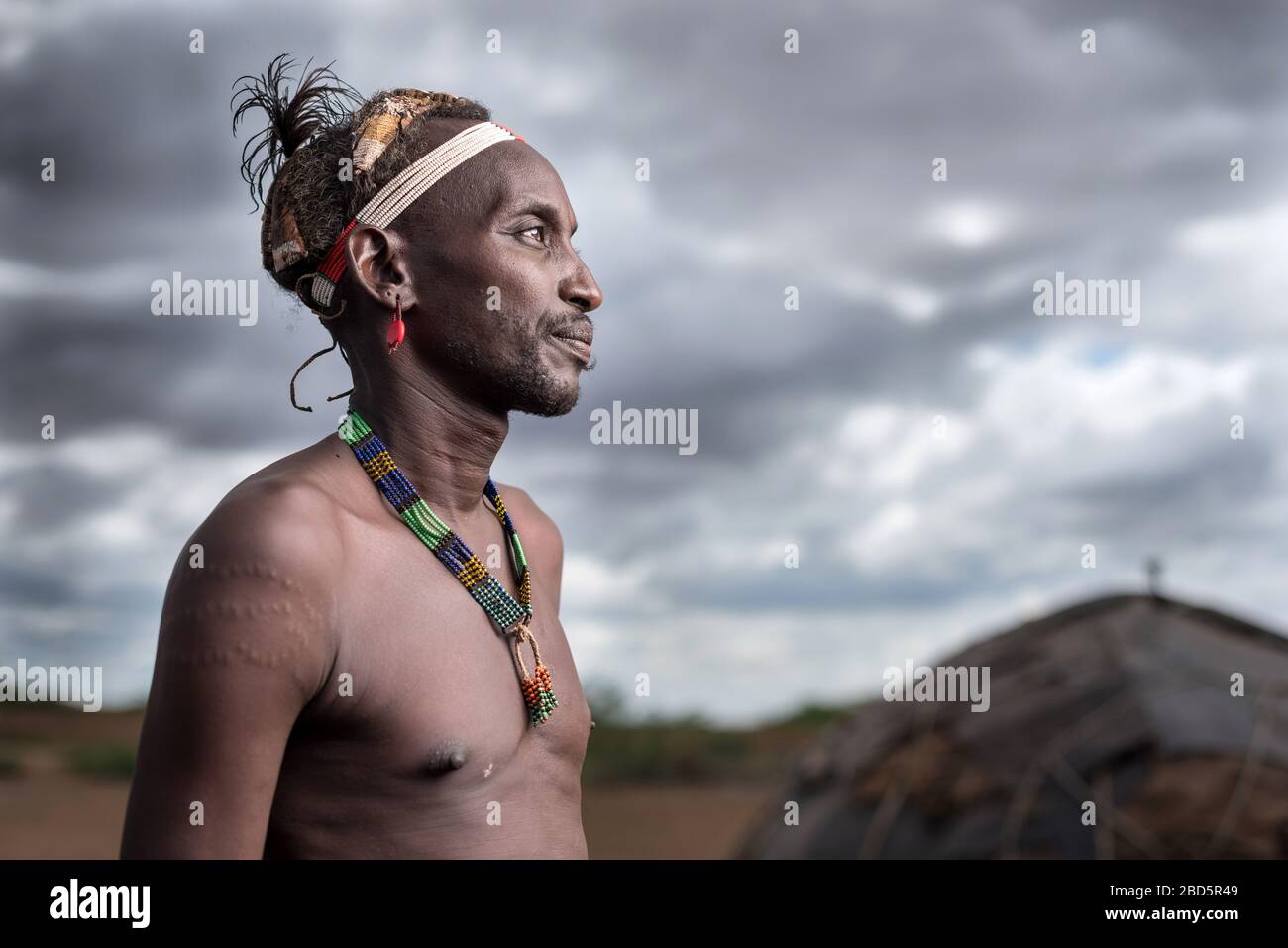 A Male Member Of The Dassanetch Ethnic Group Or Tribe Poses Holding His Hand Carved Chair