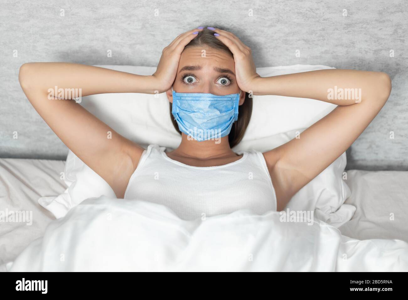 Scared Woman Touching Head In Fear Lying In Bed Indoor Stock Photo - Alamy